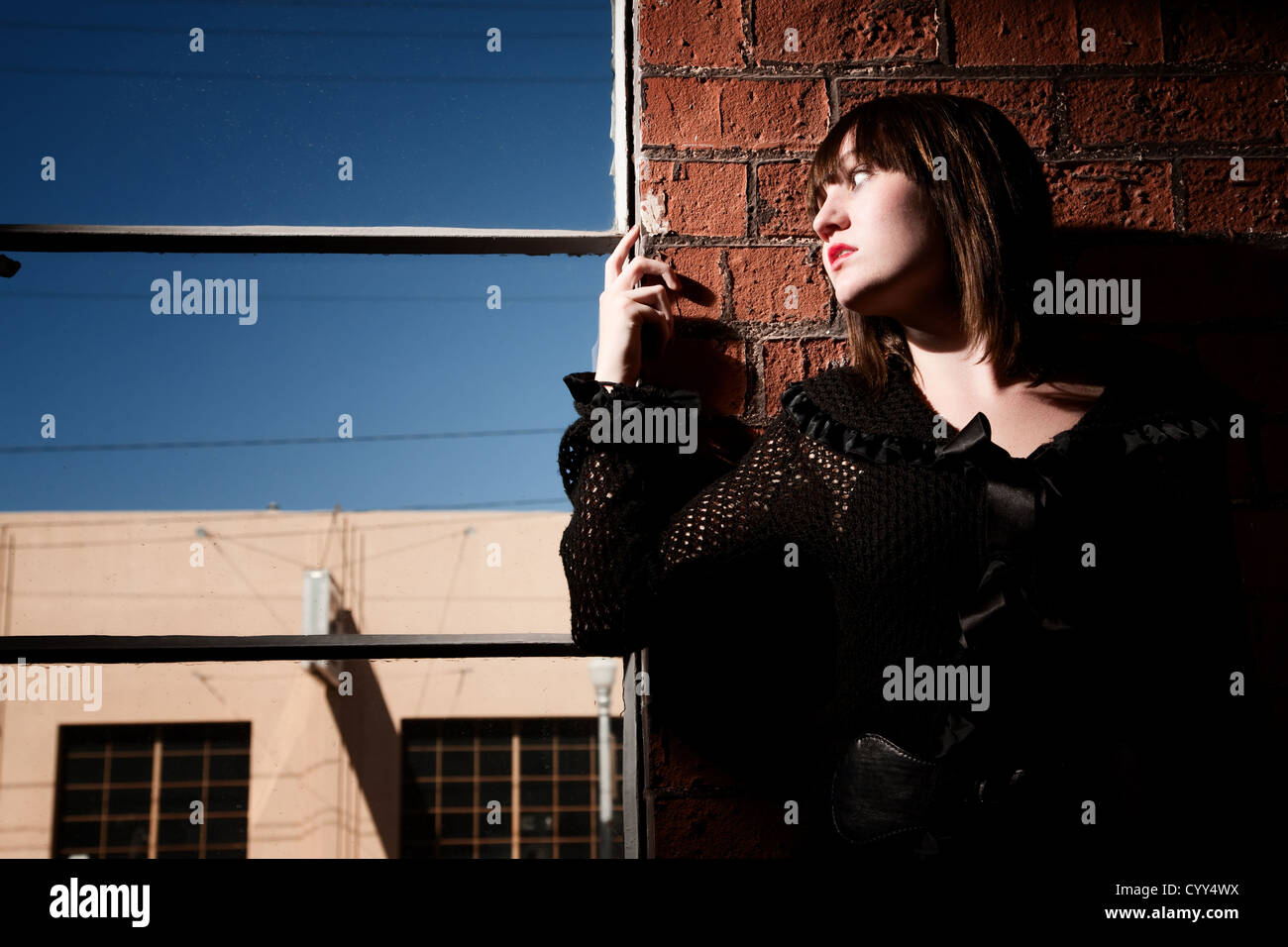 Young girl hiding and peeking out a window Stock Photo - Alamy