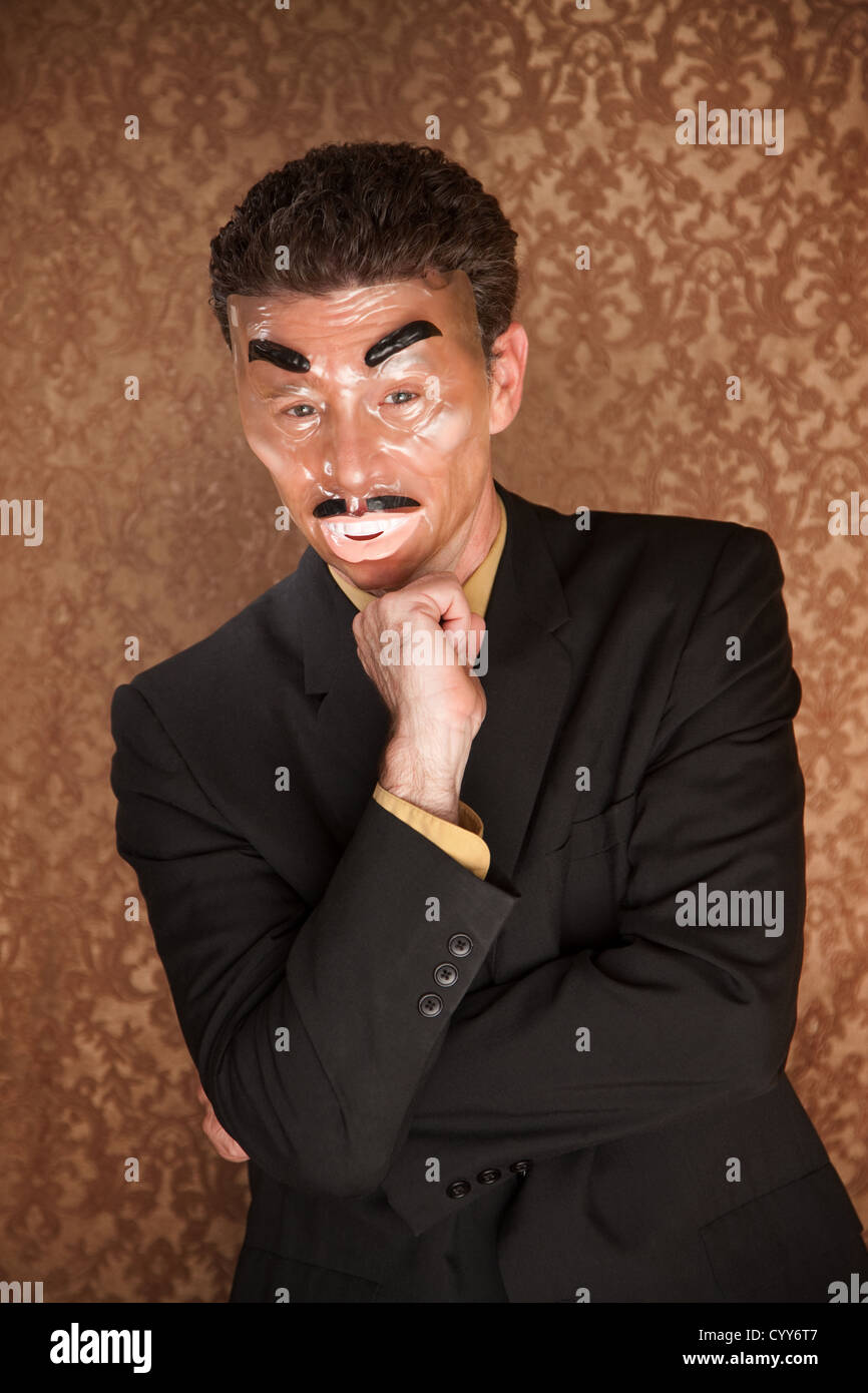 Businessman with plastic mask on damask background Stock Photo - Alamy
