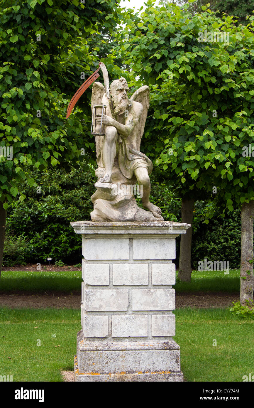 Statue of Old Father Time in Sandringham. Green trees aboce and around ...