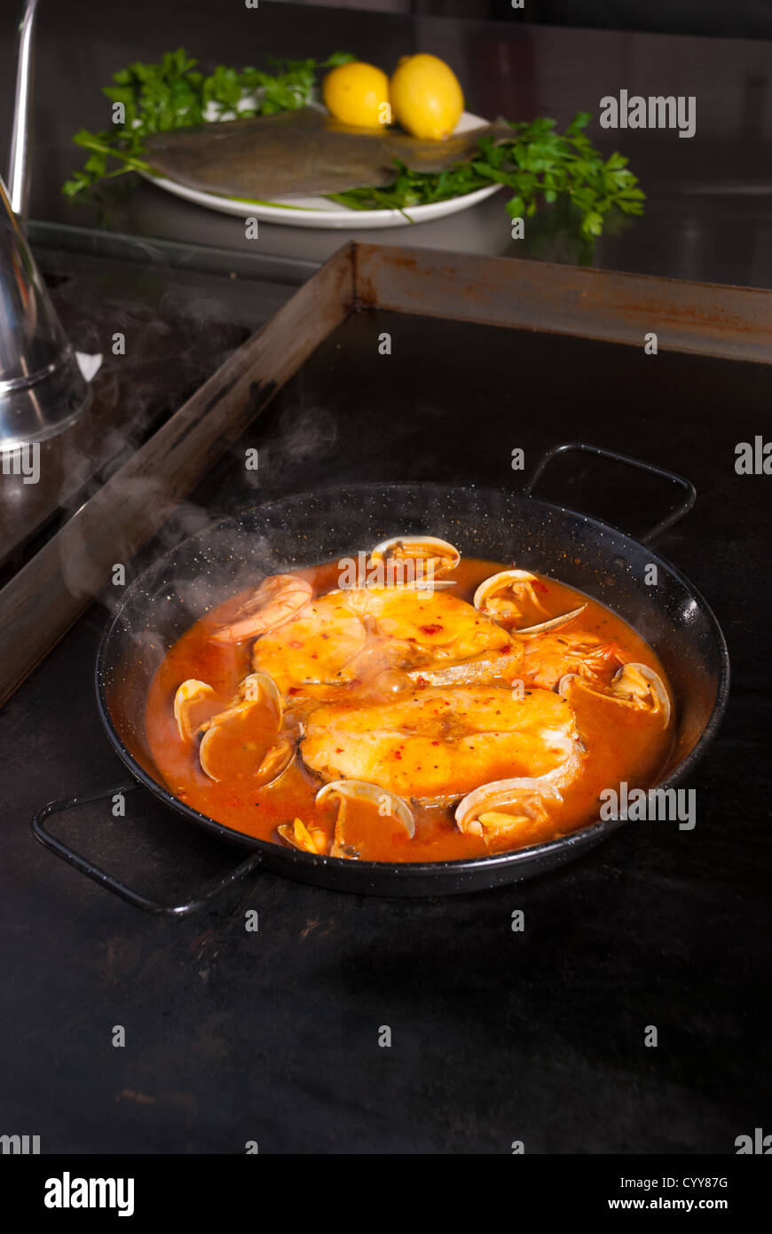 Cooking hake in cider sauce, a traditional Spanish recipe Stock Photo ...
