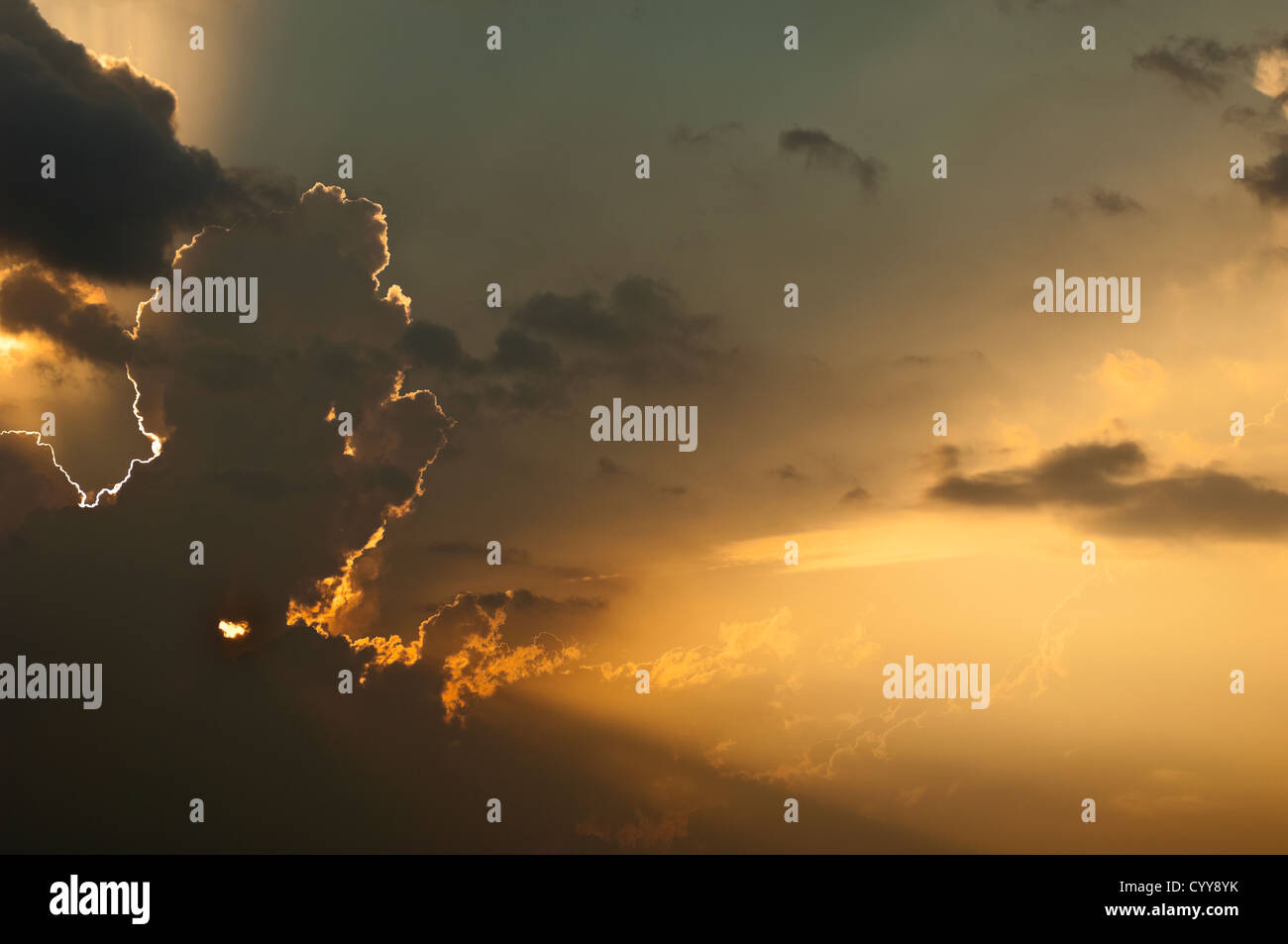 Dramatic sunburst through cumulus clouds in the evening Stock Photo - Alamy