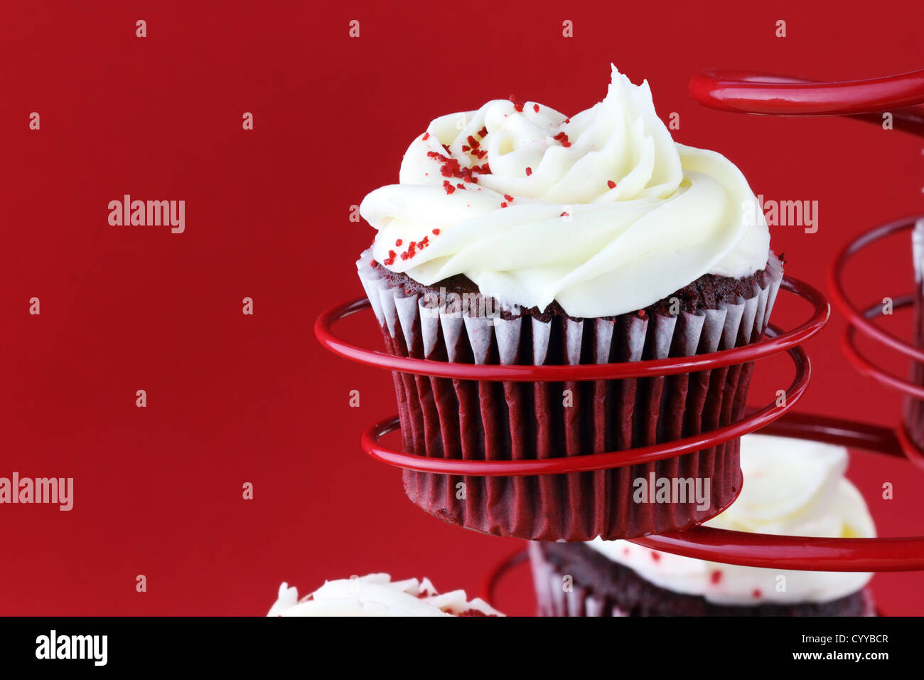 Red velvet cupcake in a red cupcake holder against a red background ...