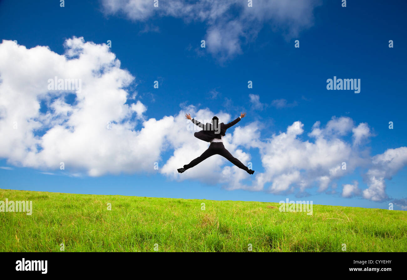 happy and successful Businessman jumping on a green meadow Stock Photo ...
