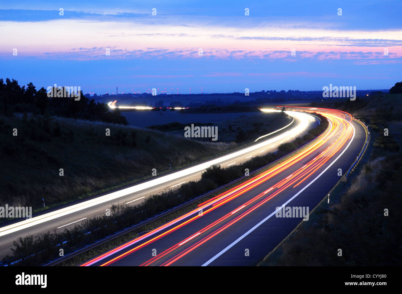 night traffic on busy highway with cars lights and blue sky Stock Photo ...