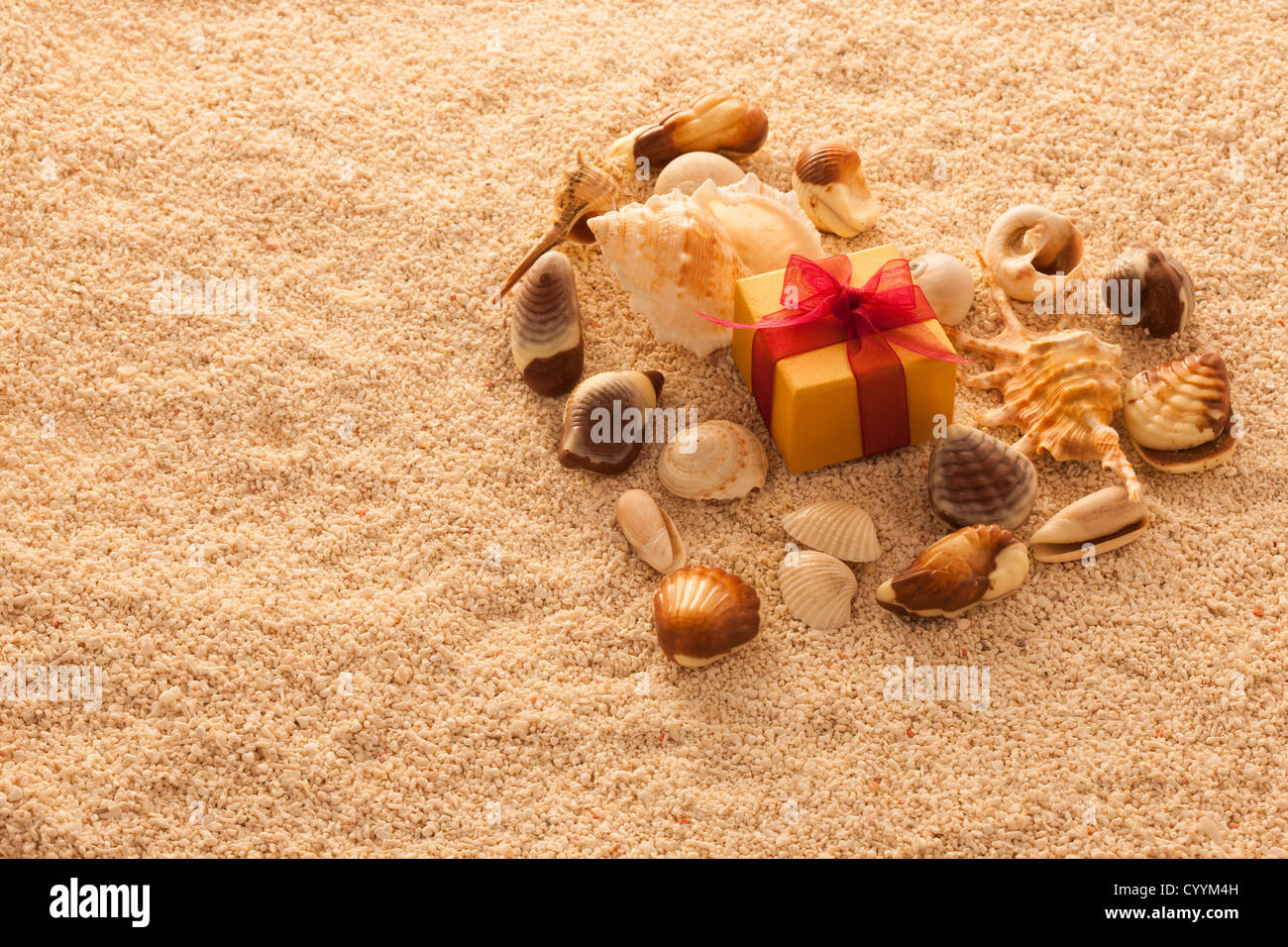Shell and gift box in sand Stock Photo - Alamy