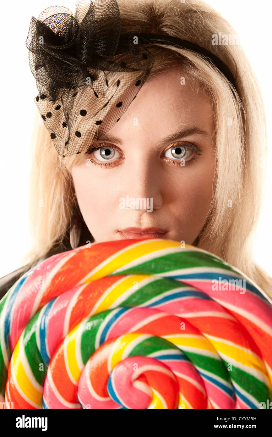 Pretty young blonde woman with large colorful lollipop Stock Photo - Alamy