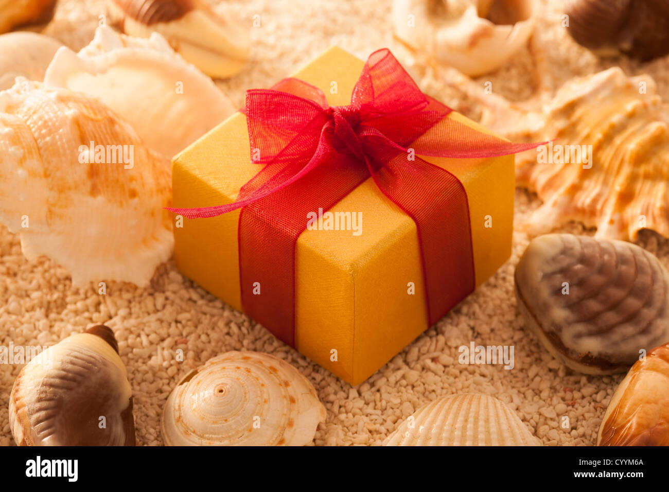 Shell and gift box in sand Stock Photo - Alamy
