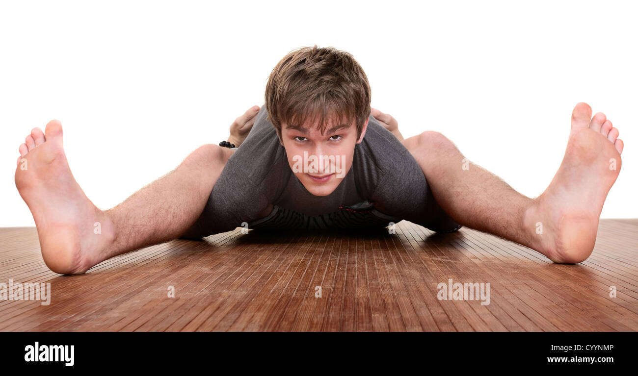 Flexible young Caucasian man exercises over white background Stock ...