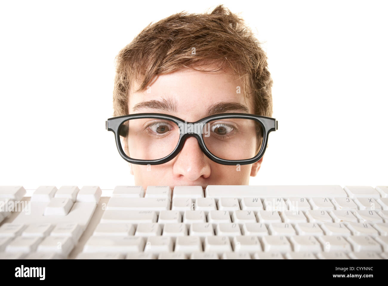 Young Caucasian man behind a computer keyboard over white background ...