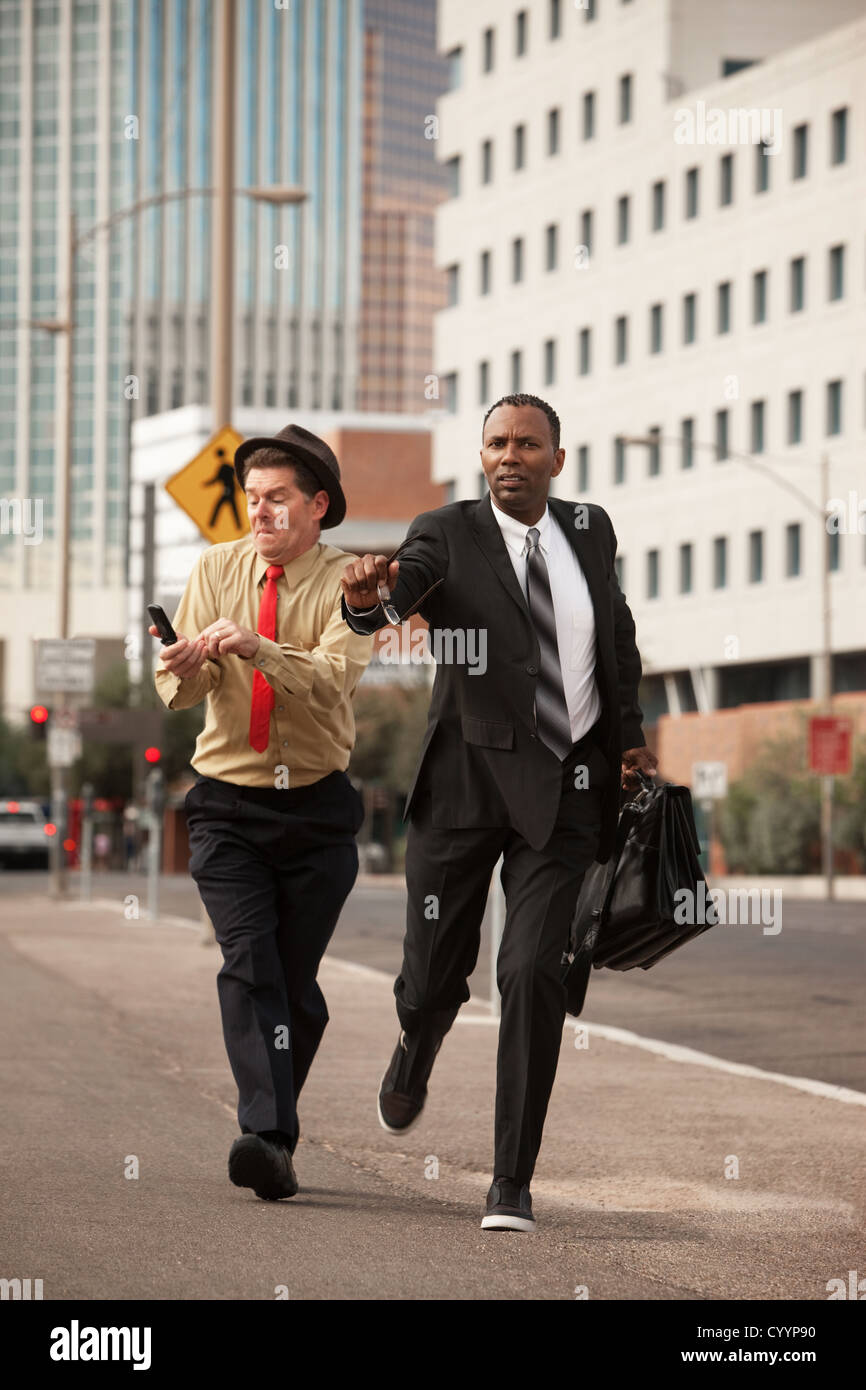 Two businessmen try to outrun each other down the street Stock Photo ...