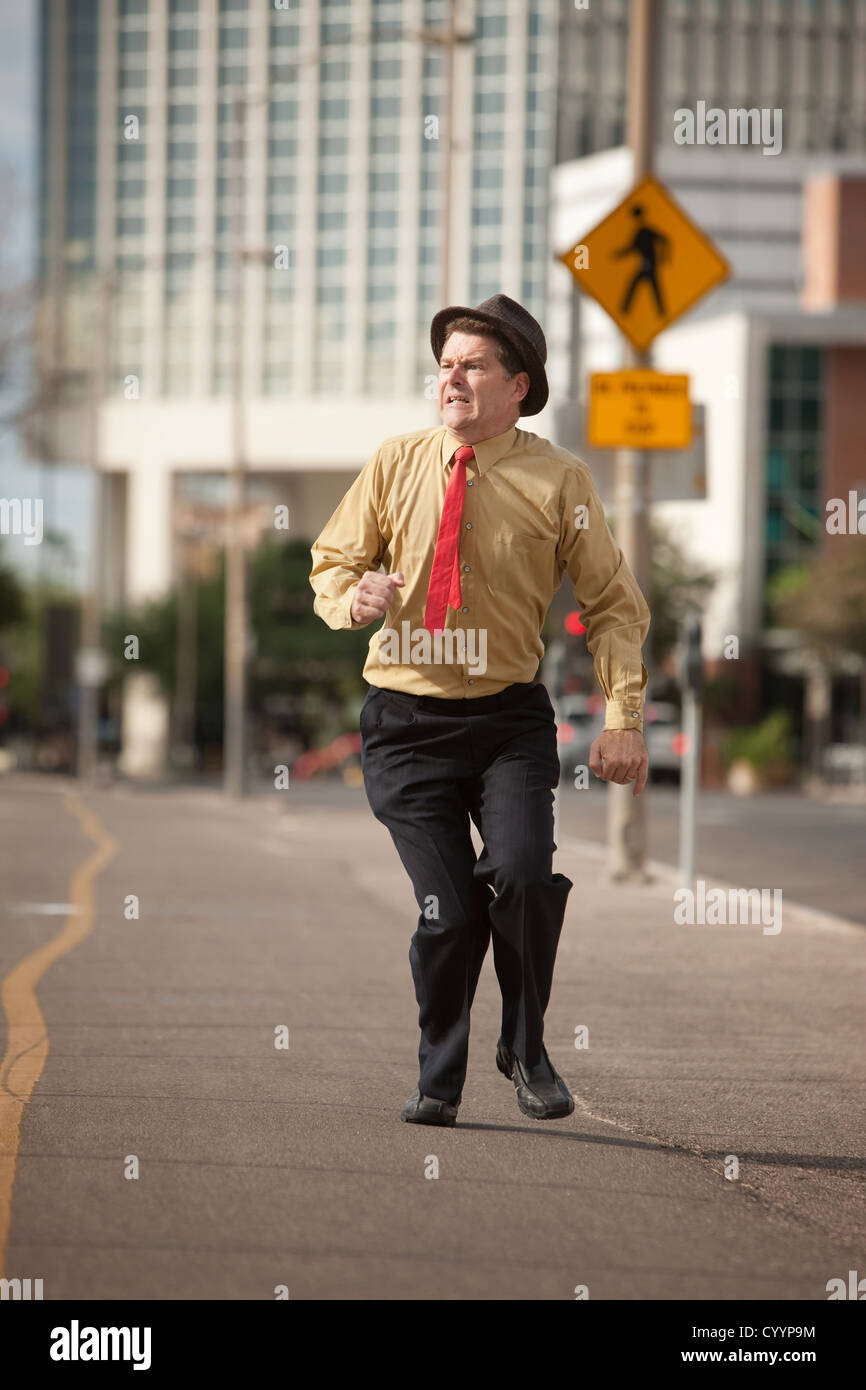 Scared Caucasian businessman run down the street Stock Photo - Alamy