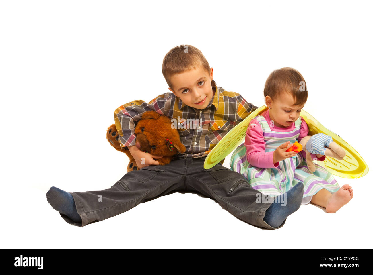 Happy kids holding toys and sitting on floor isolated on white ...