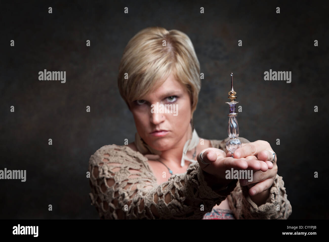 Caucasian witch holds up a potion bottle Stock Photo - Alamy