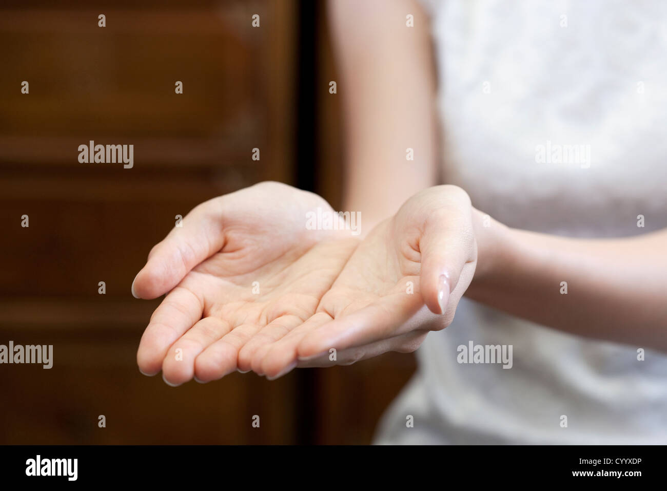 Young woman with hands cupped Stock Photo - Alamy