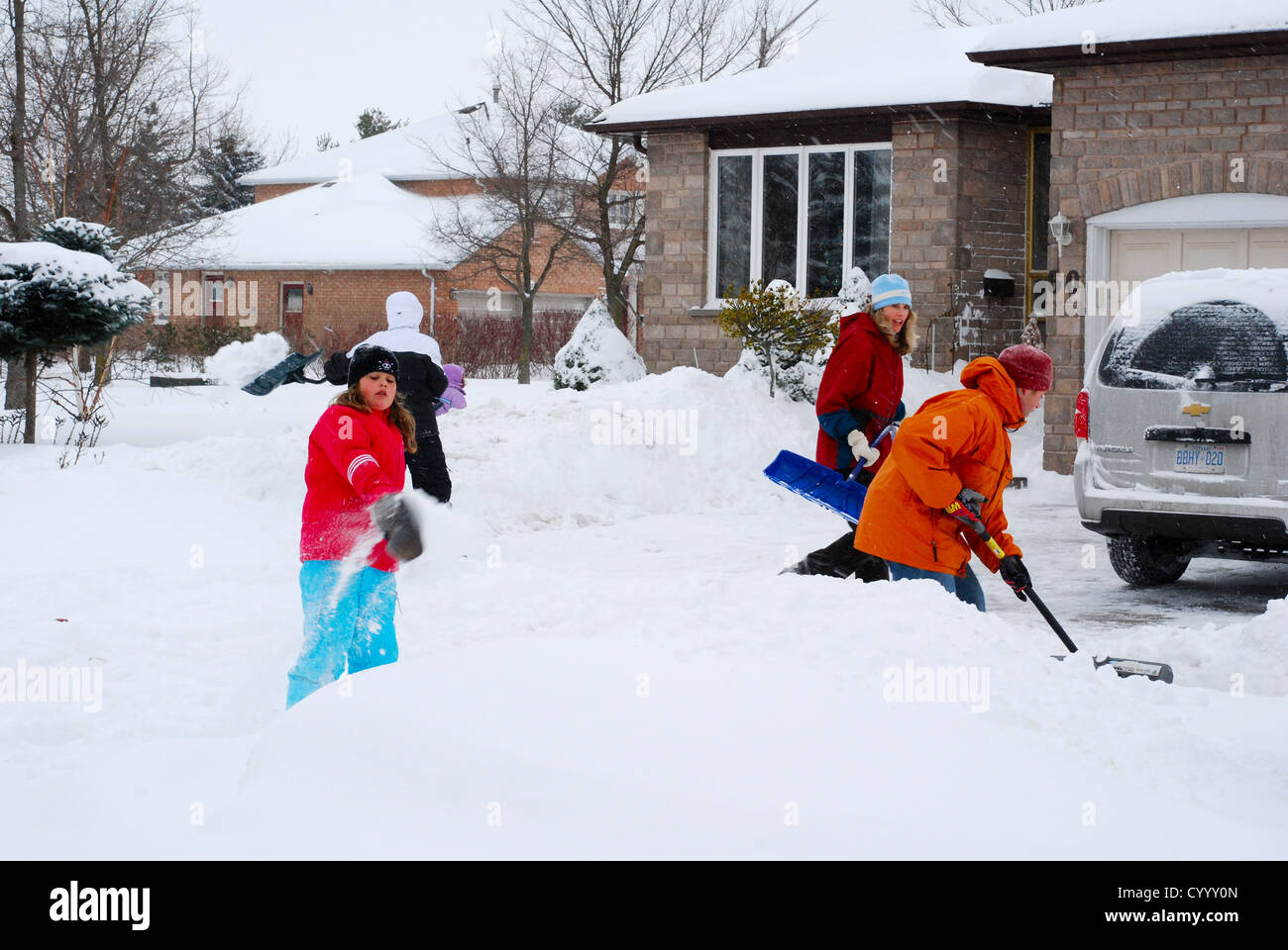 Family clearing snow from driveway Stock Photo - Alamy