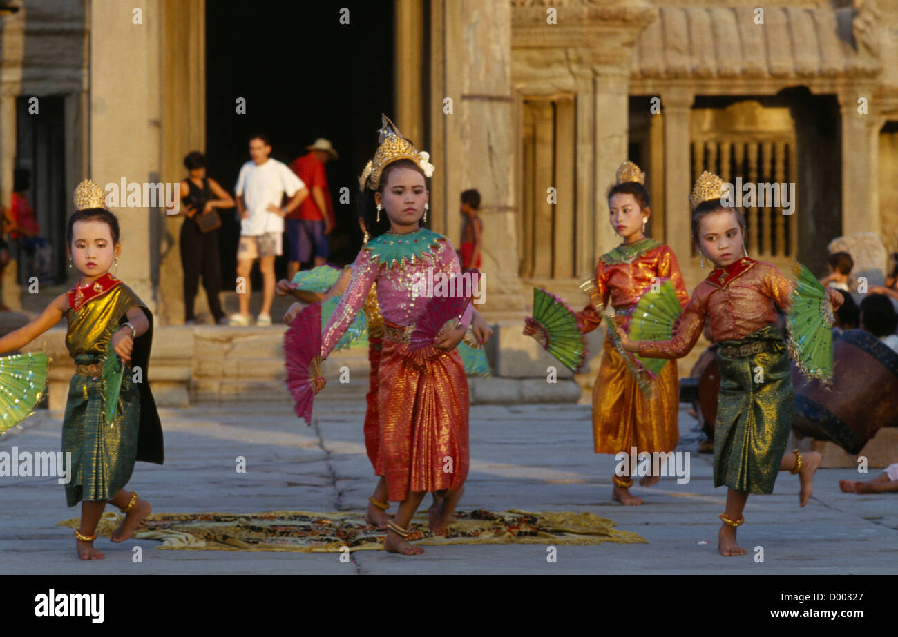 Child dancers in traditional dress with tourists framed by temple ...