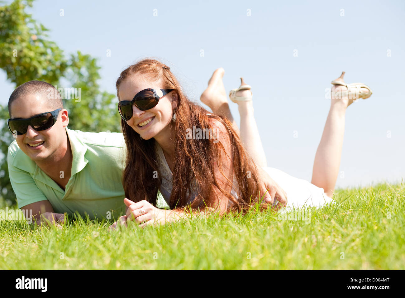 beautiful young Couple lie down on grass and smile Stock Photo - Alamy