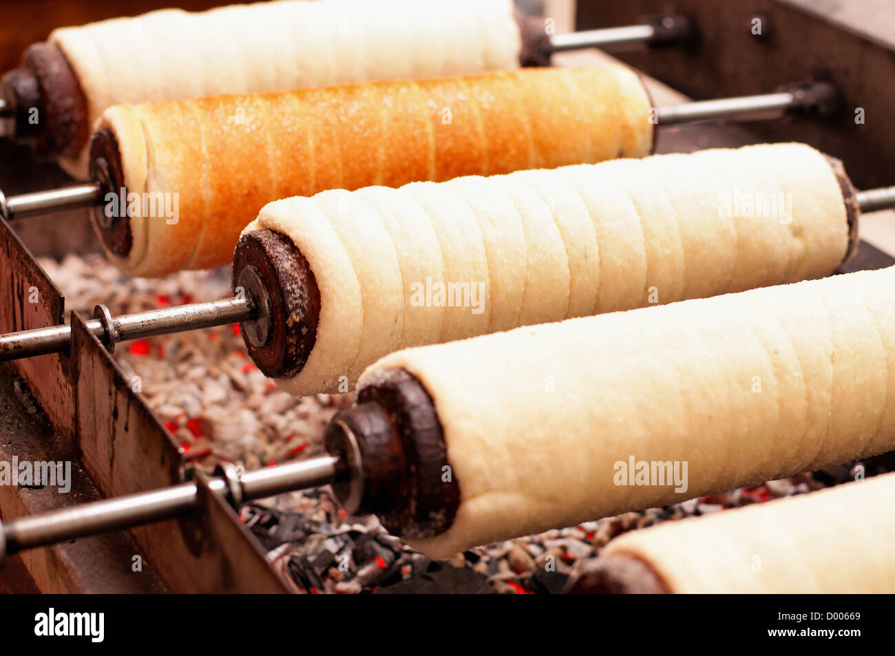 Chimney cake baking on a spit over charcoal fire Stock Photo - Alamy