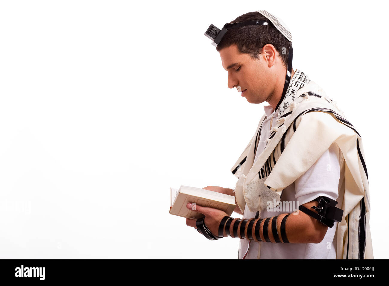Side view of young jewish man with book on white isolated background ...