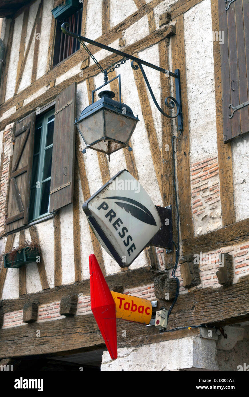 Lamp and signs on the wall of a traditional building in Eymet, in the ...