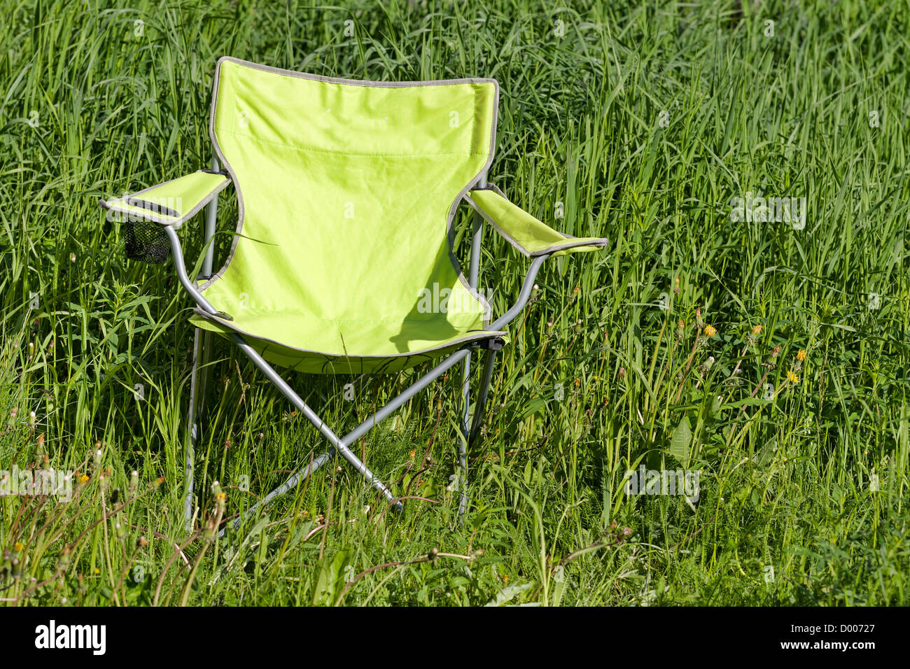 Green folding chair is on the grass Stock Photo - Alamy