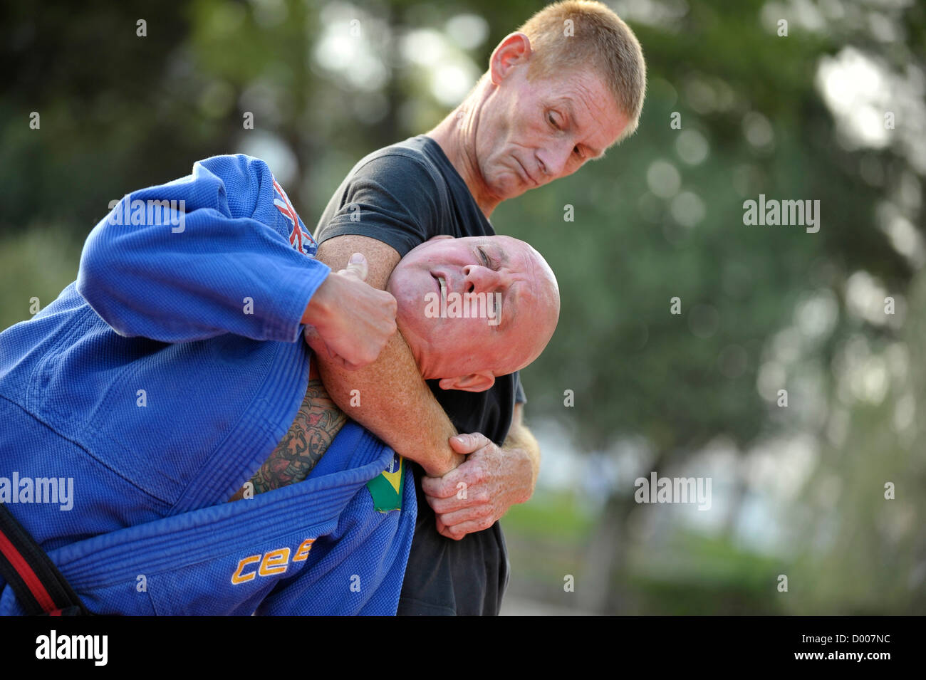 male student exercises a stranglehold on his martial arts instructor ...