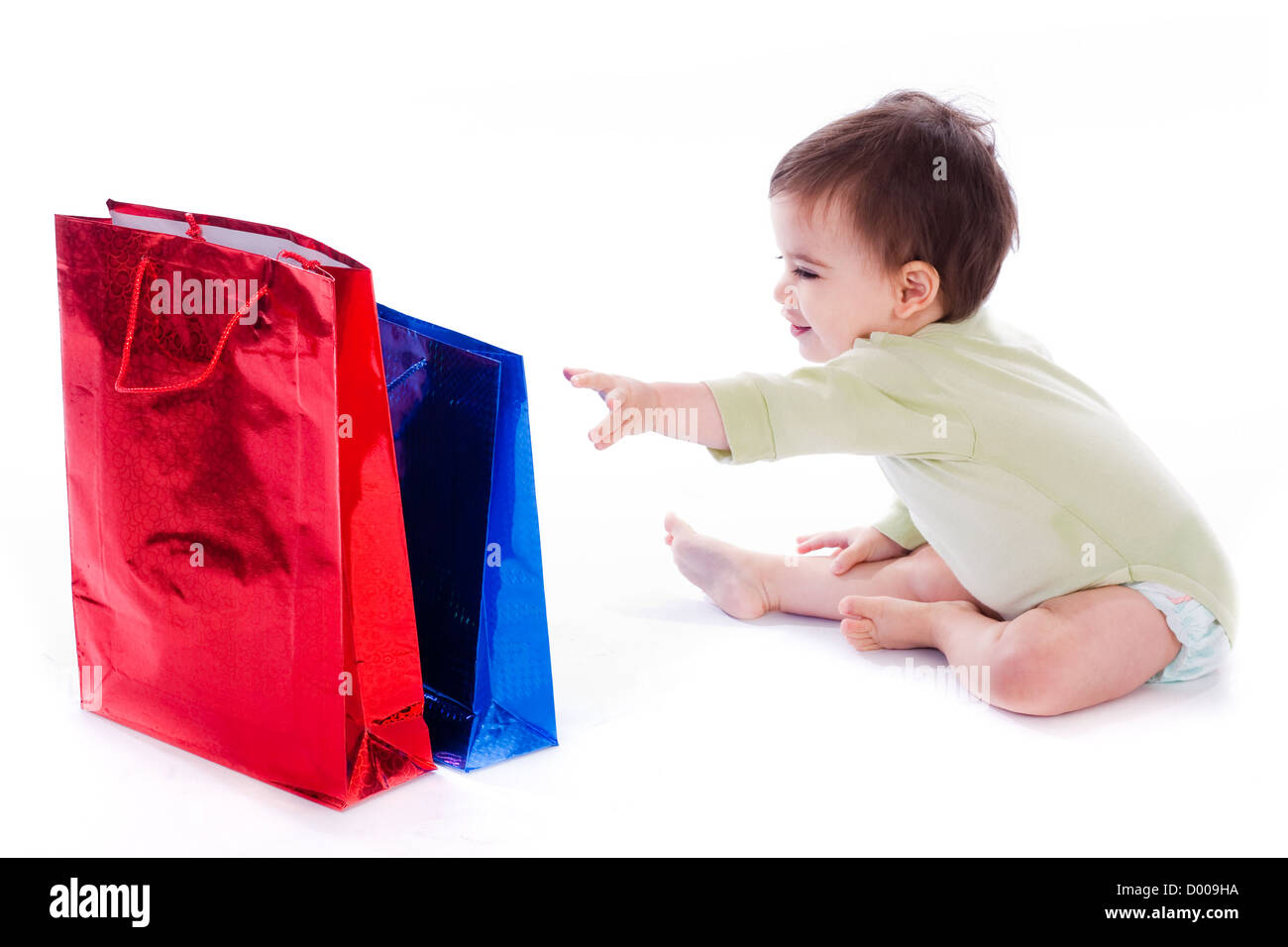 Baby trying to pull the shopping bag in a white background Stock Photo ...