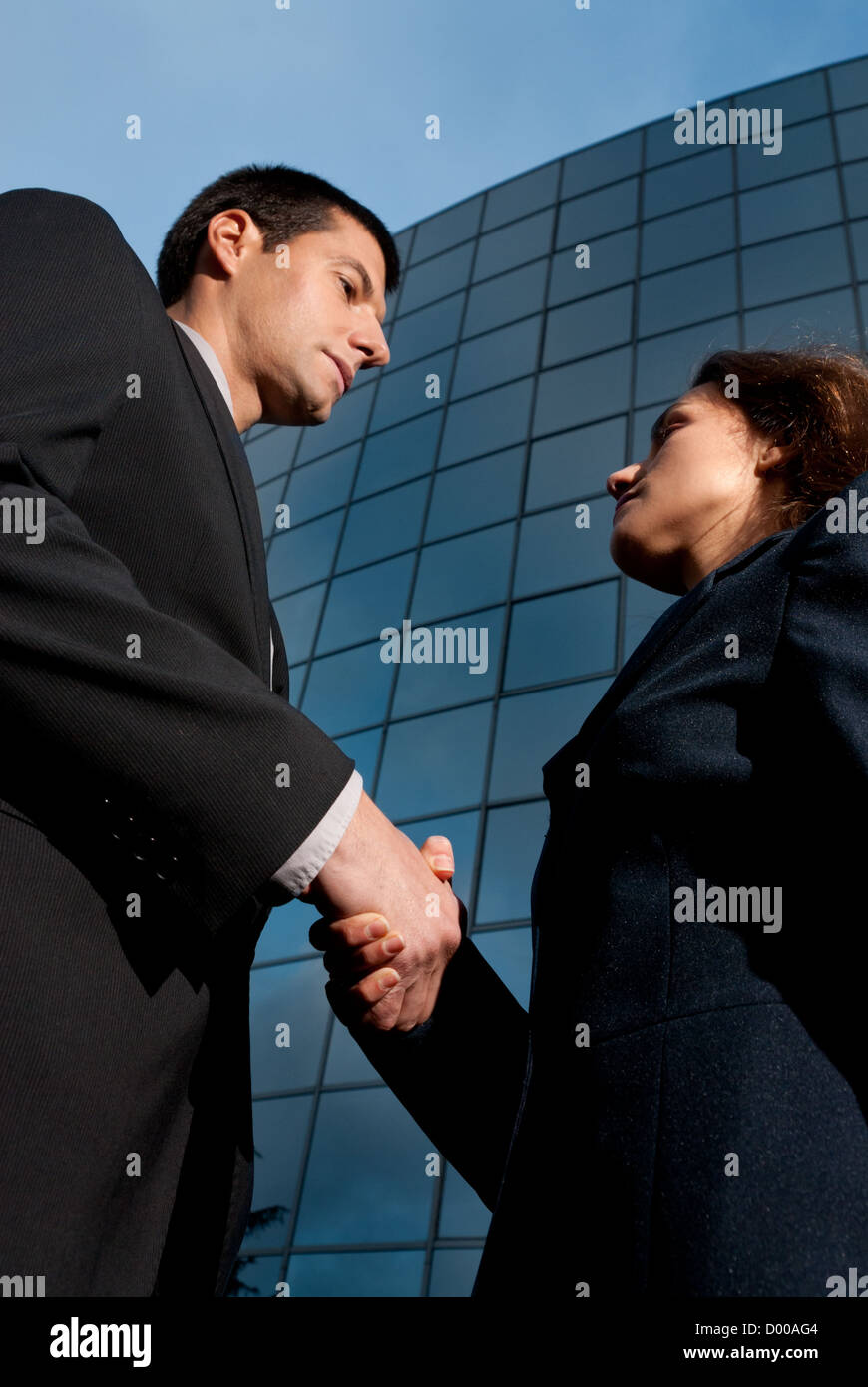 Handshake business man and woman on modern building background Stock ...
