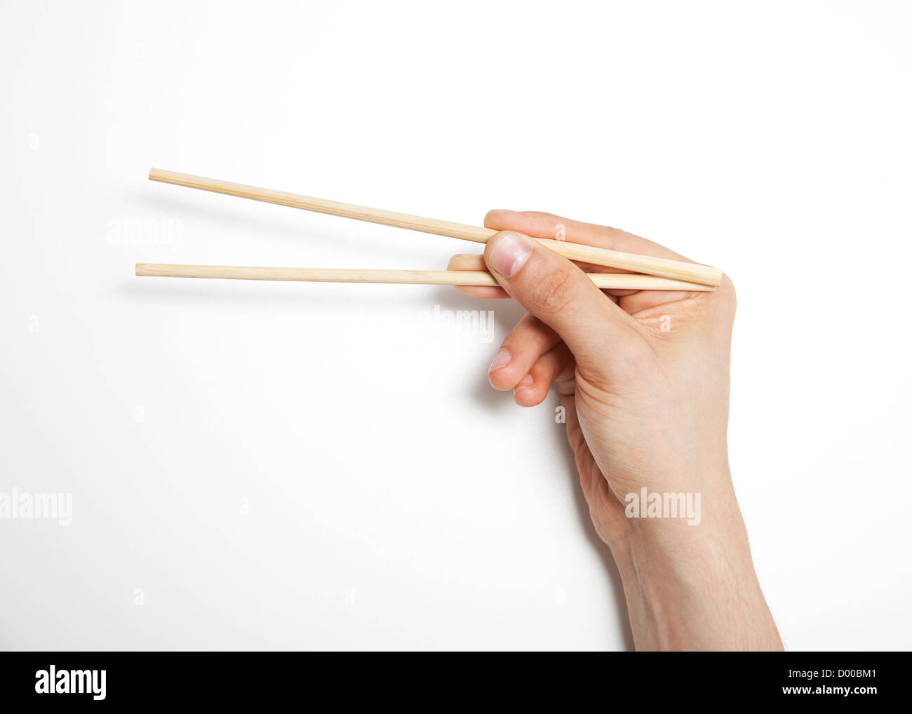 Man's hand gripping chopsticks over white background Stock Photo - Alamy