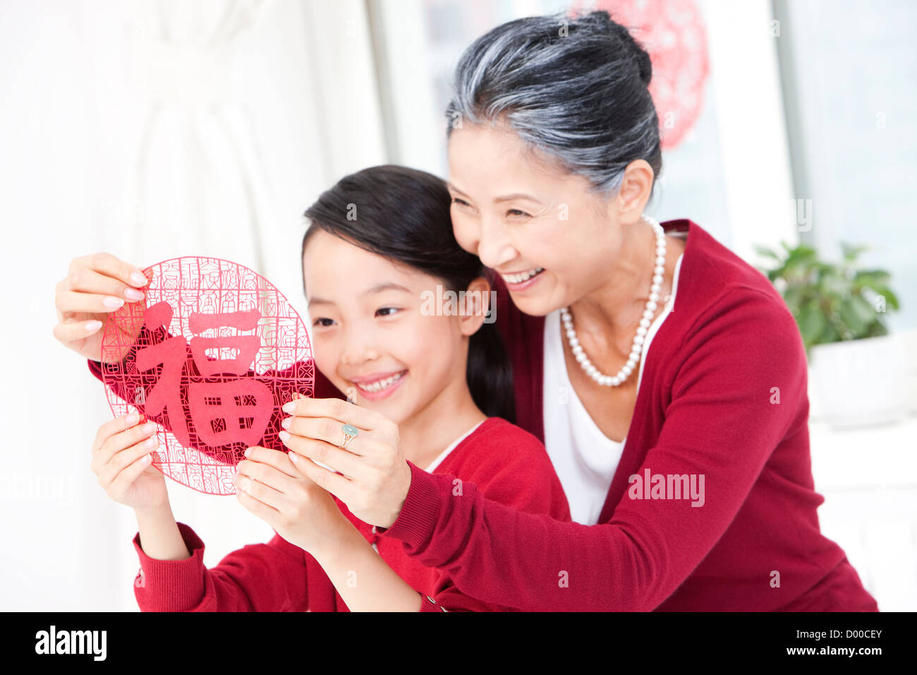 Grandmother and granddaughter holding Chinese New Year paper-cut Stock ...