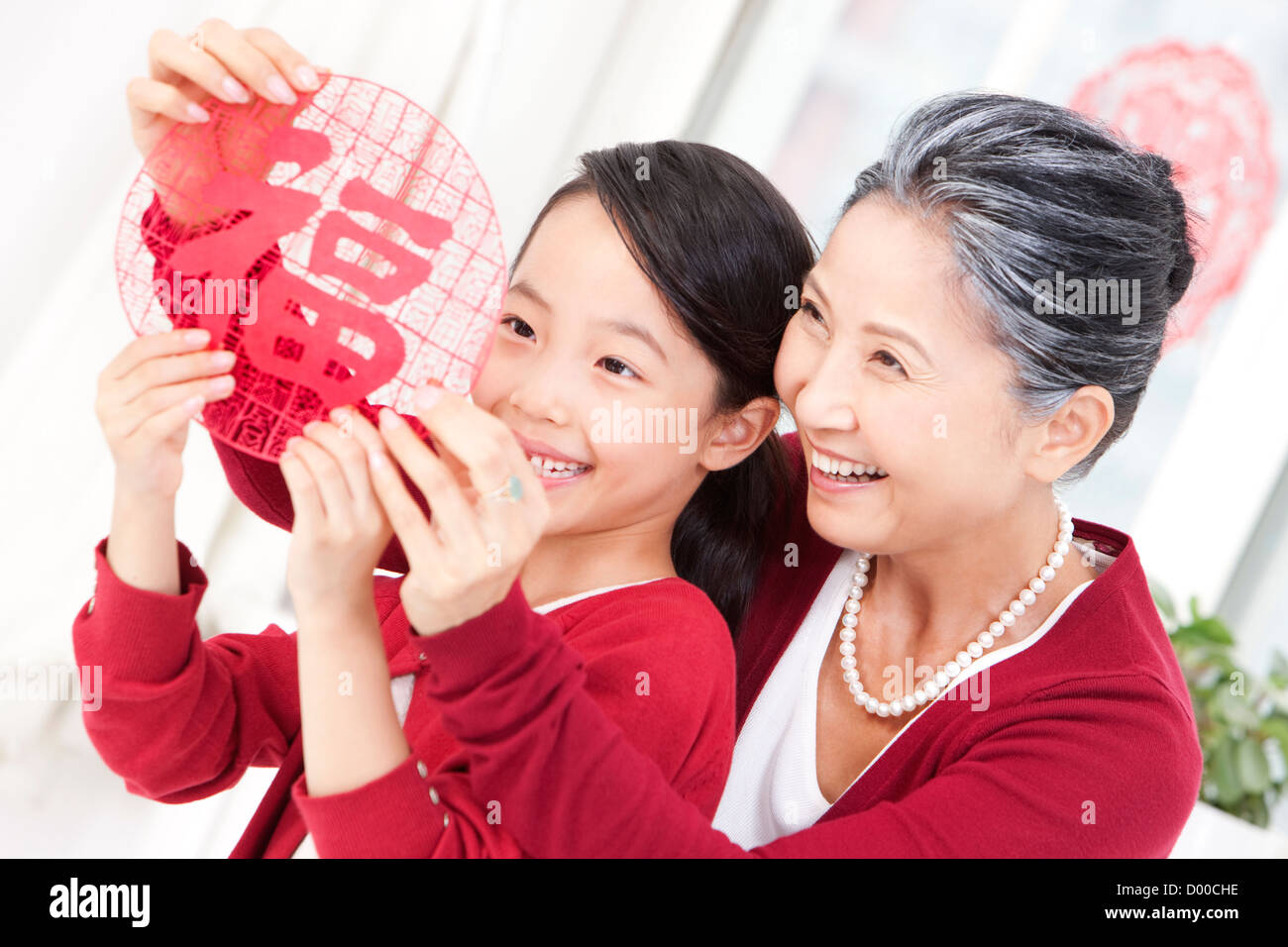 Grandmother and granddaughter holding Chinese New Year paper-cut Stock ...