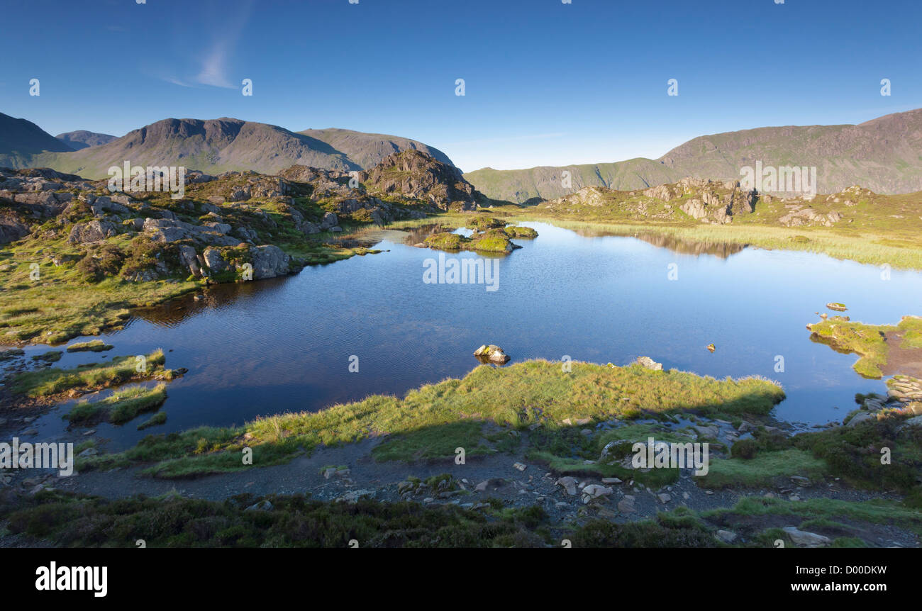 Sun rising over Innominate Tarn with Kirk Fell in the distance. Lake ...