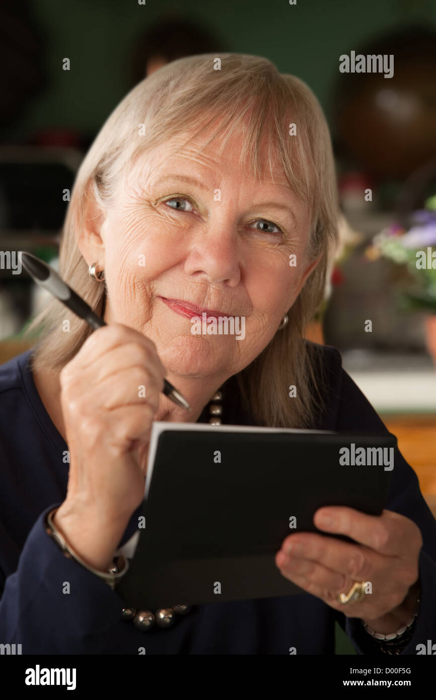 Senior woman at home with checkbook Stock Photo - Alamy
