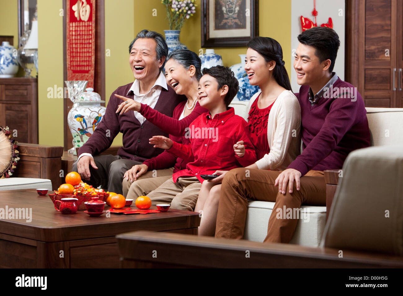 Happy family watching TV during Chinese New Year Stock Photo - Alamy