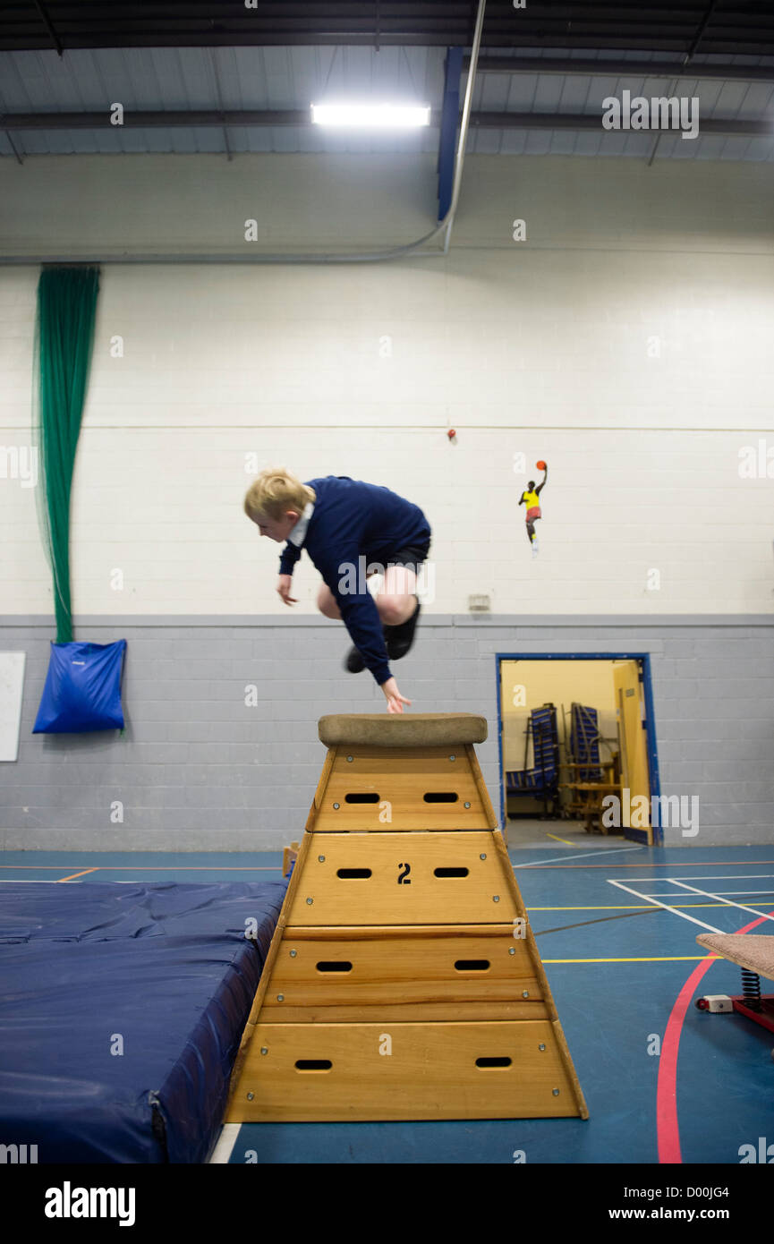 A boy vaulting in a Physical education class in the gymnasium at a ...
