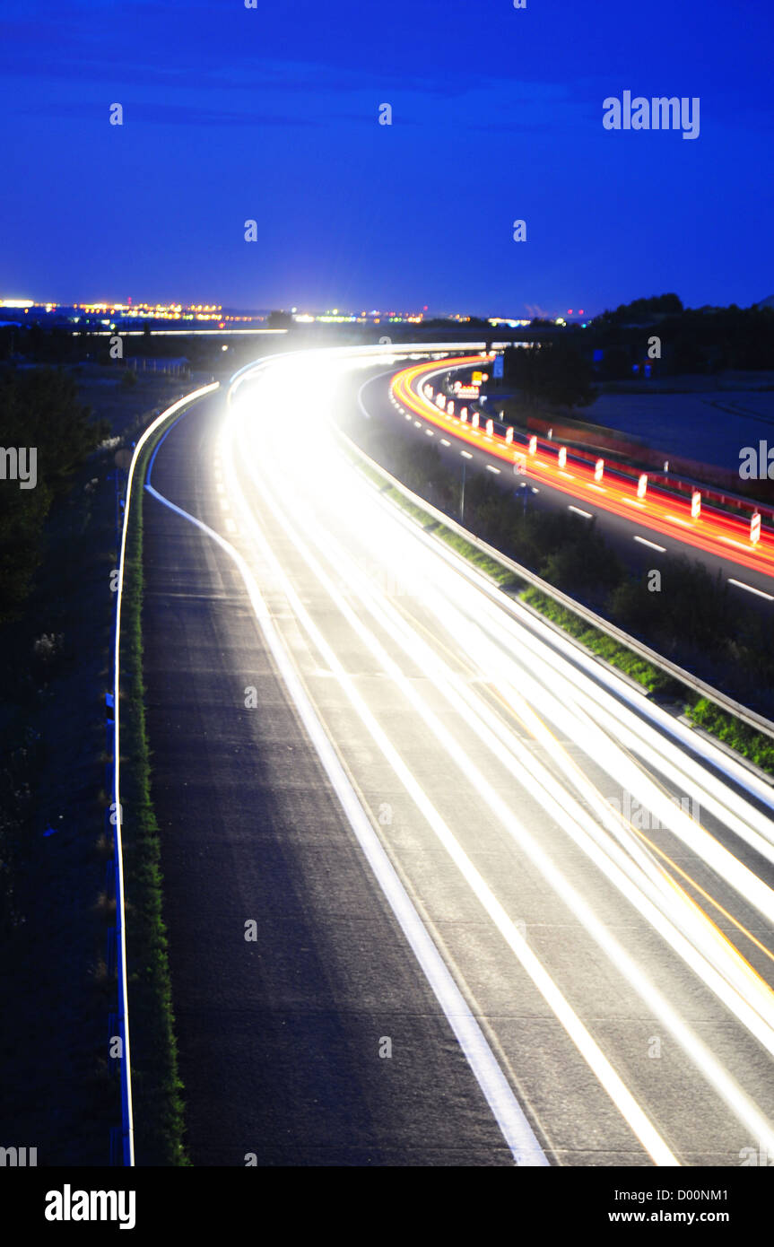 night traffic on busy highway with cars lights and blue sky Stock Photo ...