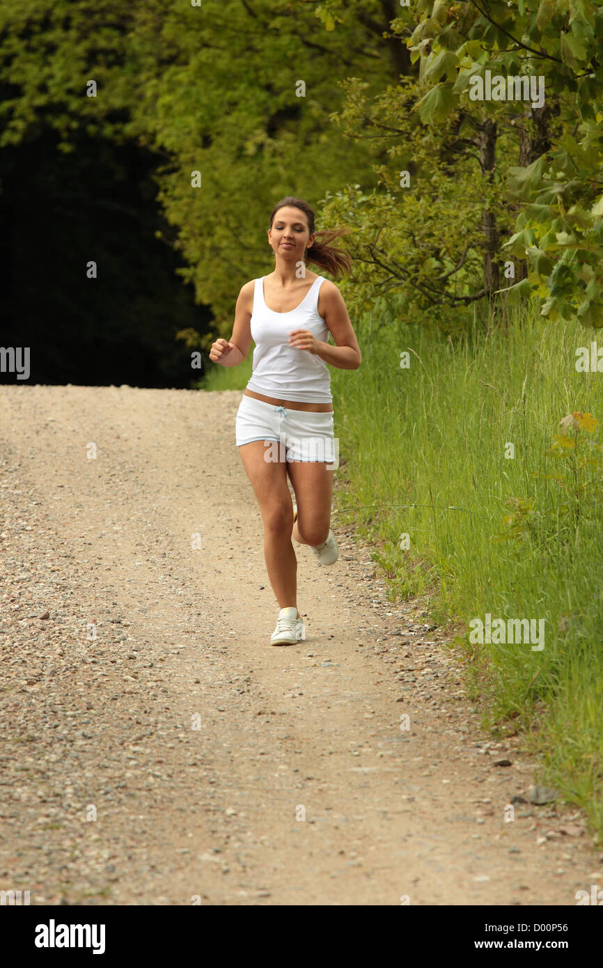 Pretty young girl runner in the forest Stock Photo - Alamy