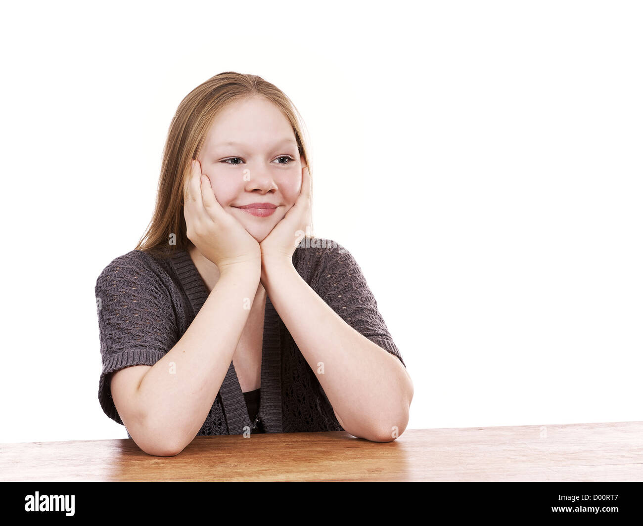 Beautiful happy young girl sitting by table on white background Stock ...