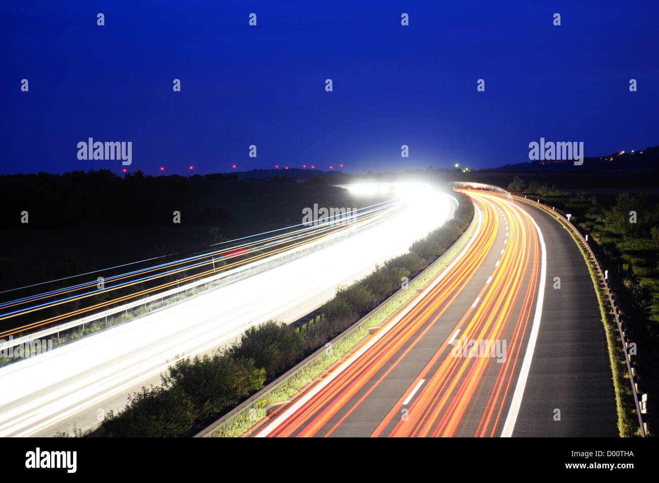 night traffic on busy highway with cars lights and blue sky Stock Photo ...