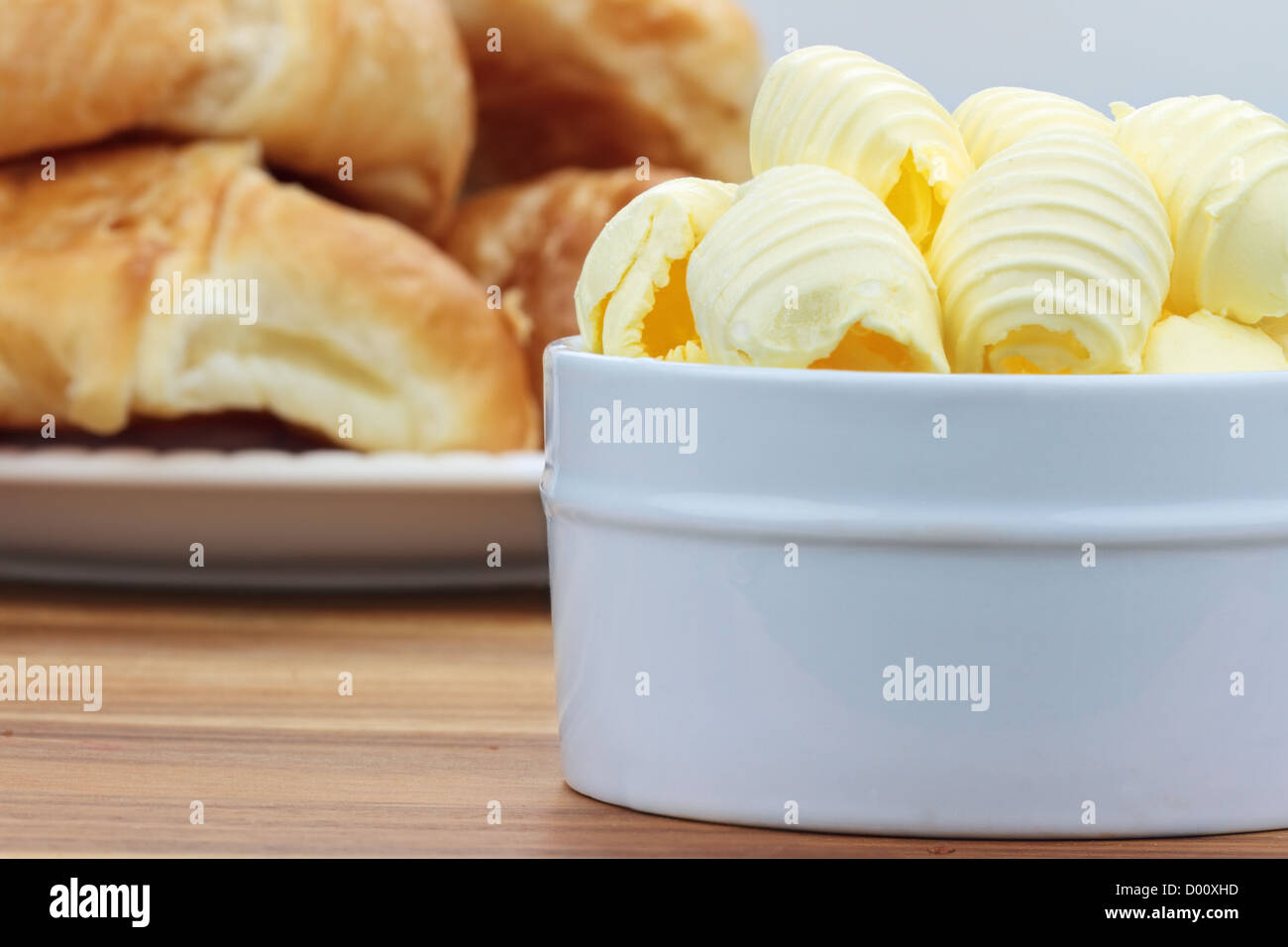 Curled butter in a dish with croissants in the background Stock Photo ...