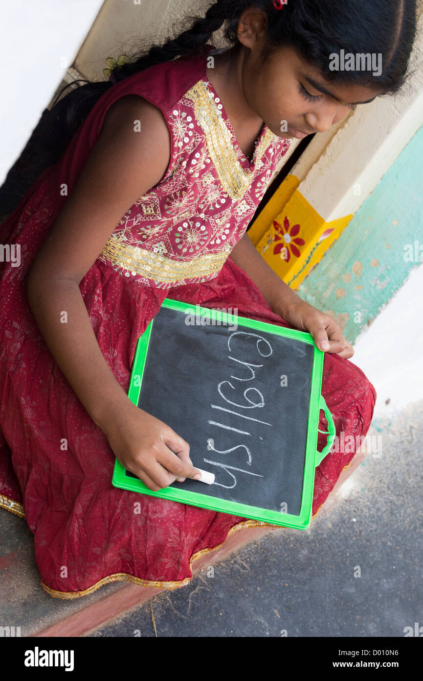 Indian village girl writing the word english on a chalkboard in a rural ...