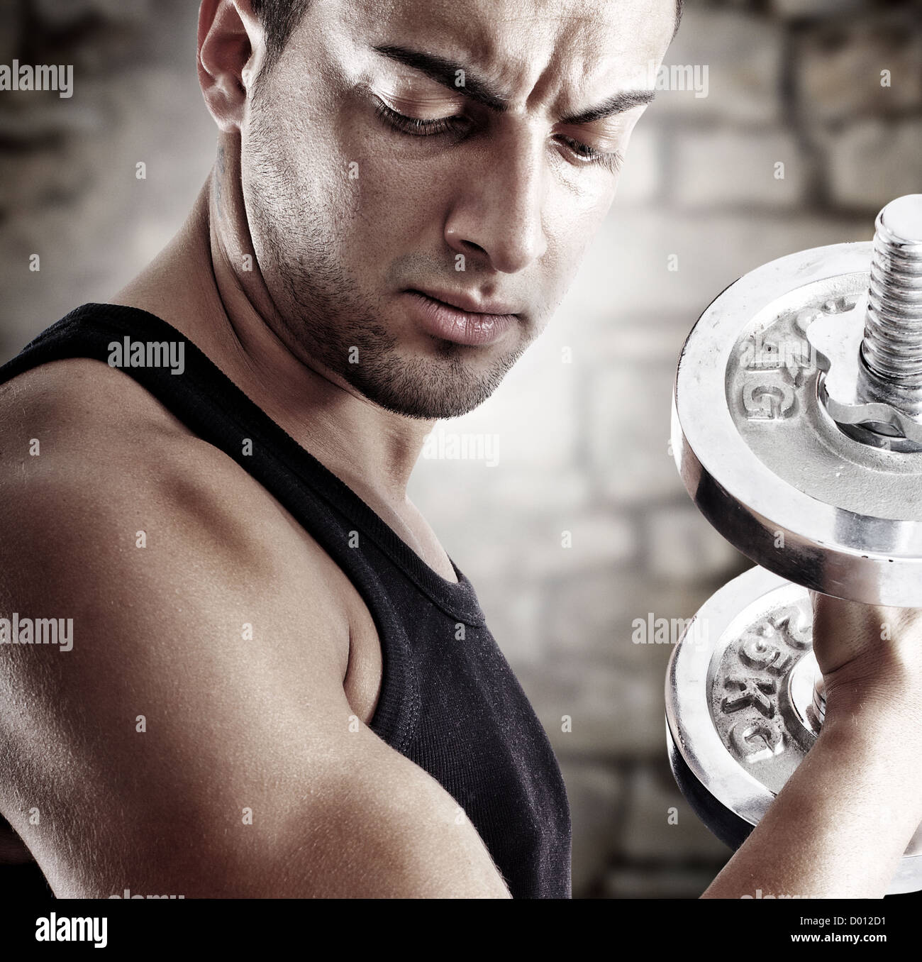 Young man doing weights lifting on stone background Stock Photo - Alamy