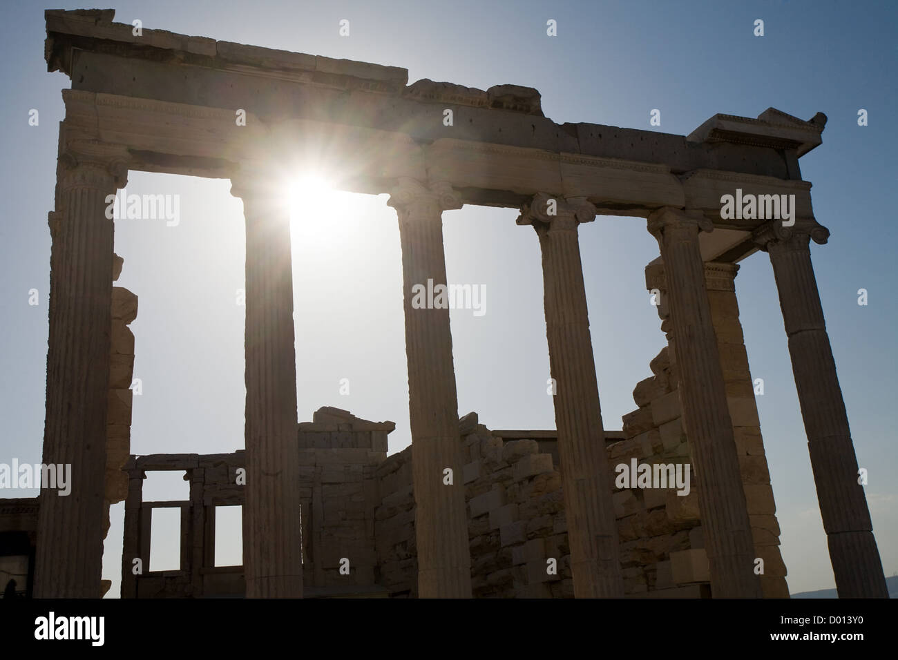 closeup portico of ancient Greek temple on sky and rays of sun background, Athens Acropolis ...