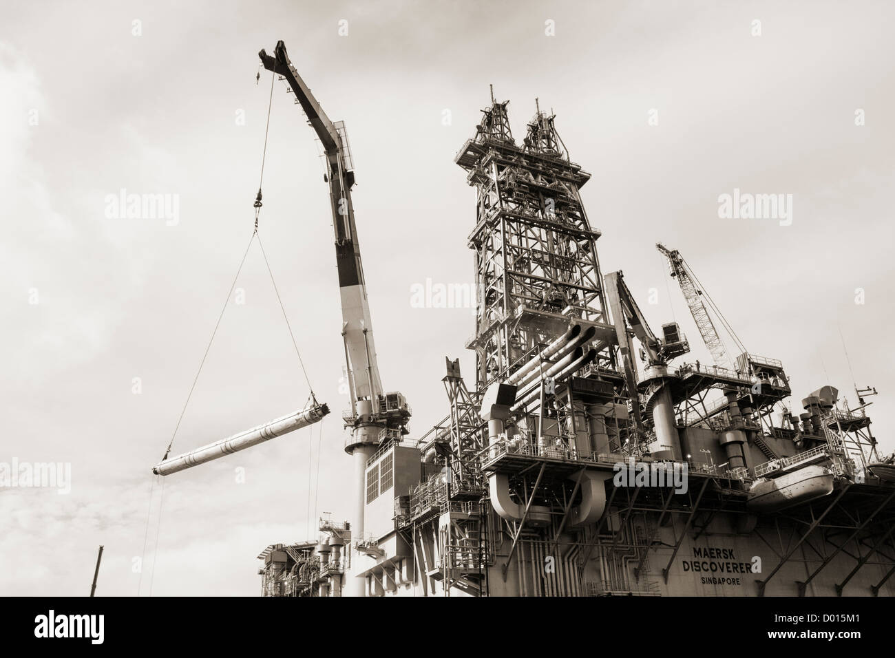 Oil rig crane lifting pipe from dockside Stock Photo - Alamy