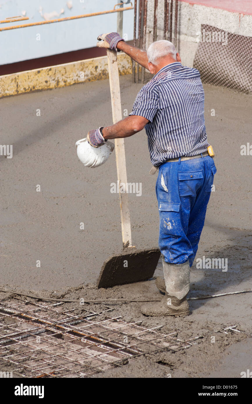 Construction worker smoothing cement on building site in Spain Stock ...