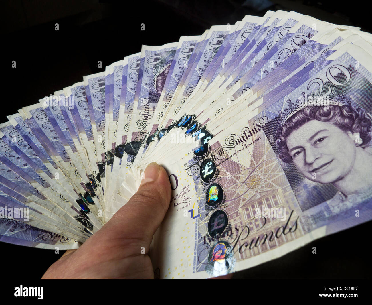 Twenty pound notes held in a mans hand Stock Photo - Alamy