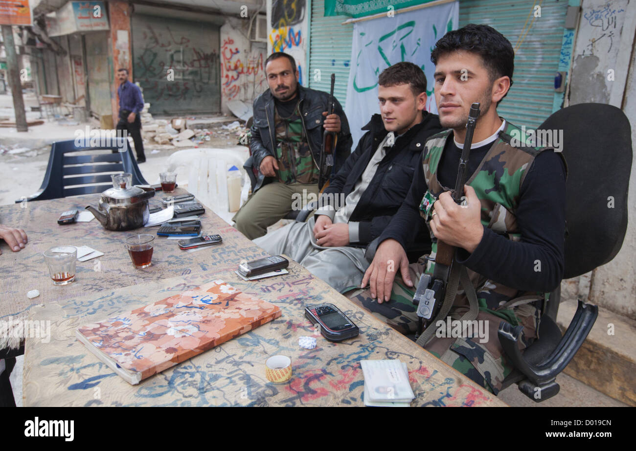 Free Syrian Army fighters hold civilians cell phones and IDs at a ...
