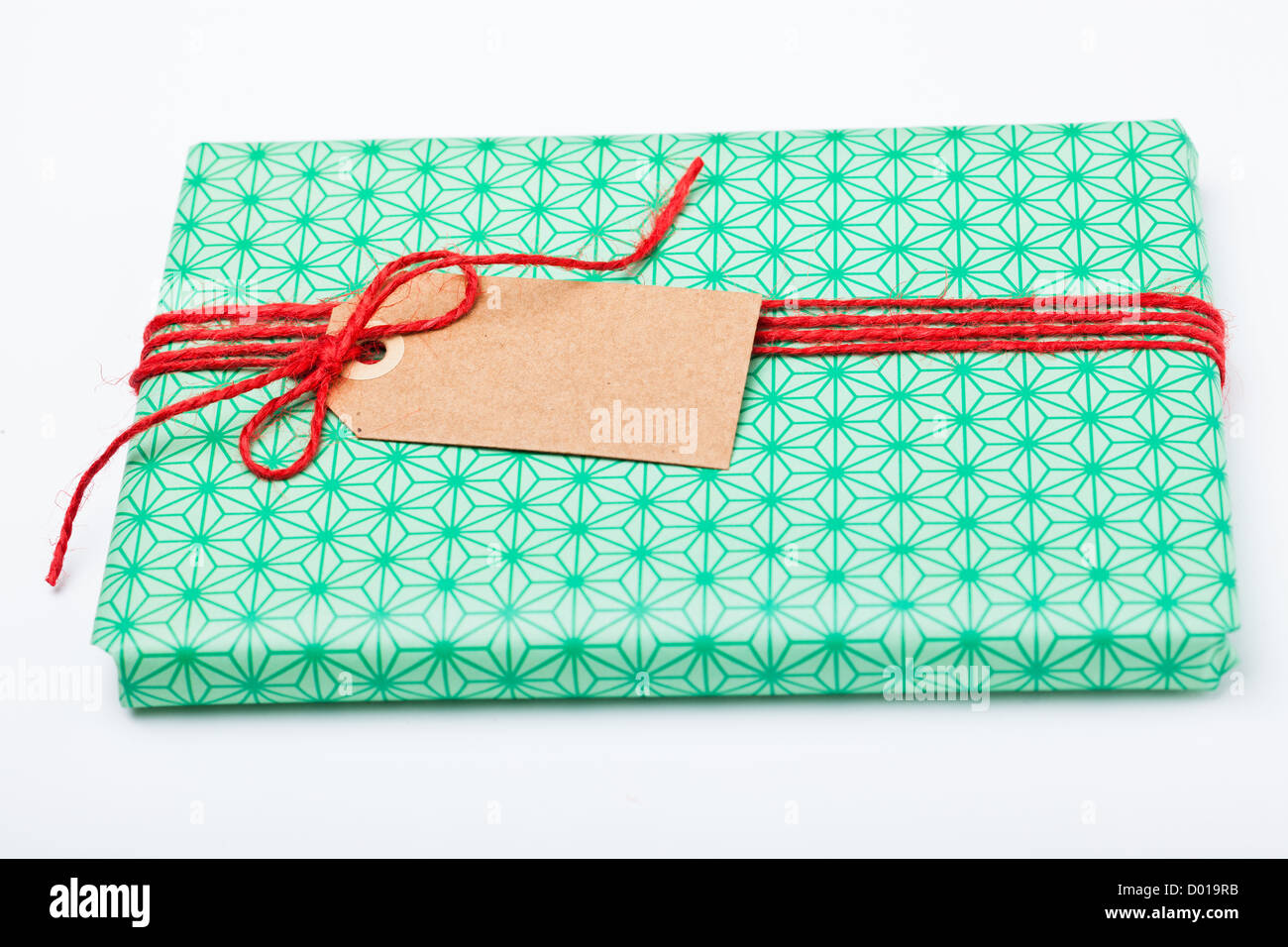 Simple gift with red string and brown cardboard tag Stock Photo - Alamy