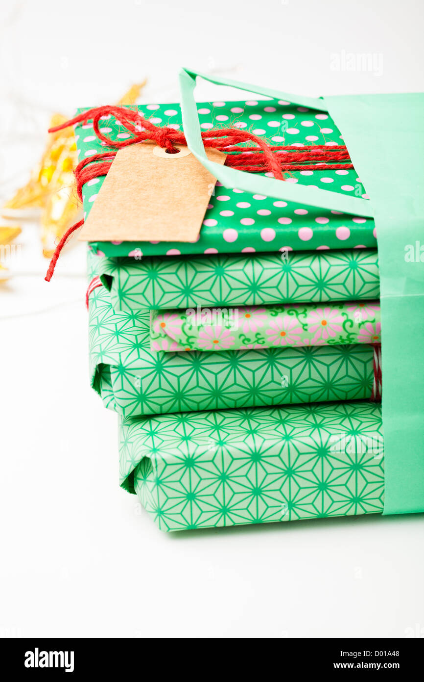 Close up of stack of gifts in bag and gold decorations on white ...
