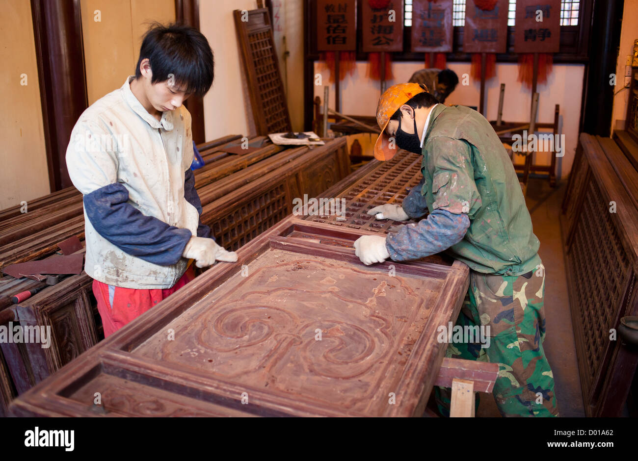 Chinese workers repairing an old door in a temple Stock Photo - Alamy